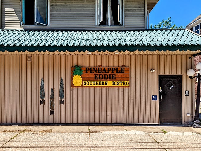 The teal-trimmed roof and cheerful pineapple sign of Pineapple Eddie Southern Bistro beckon hungry travelers like a Southern lighthouse in Erie's culinary landscape.
