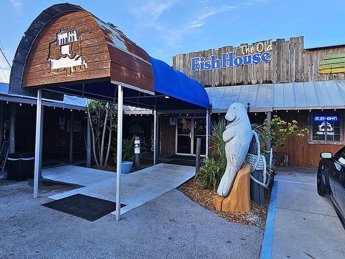 The weathered wooden exterior and iconic manatee statue aren't trying to impress anyone—they're too busy guarding the entrance to seafood paradise.