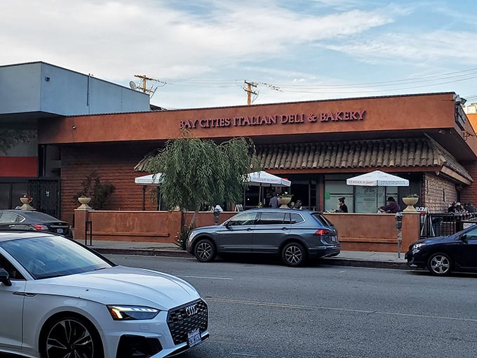 The unassuming terra-cotta exterior of Bay Cities hides culinary treasures within. Like finding a Lamborghini parked in a suburban garage—unexpected brilliance awaits.