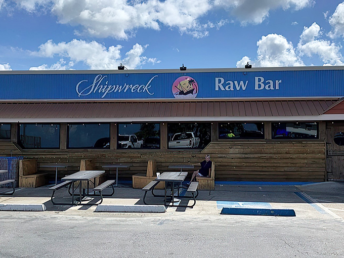 The weathered wooden exterior and bright blue corrugated metal isn't trying to impress you—it's saving all that energy for what's on your plate.