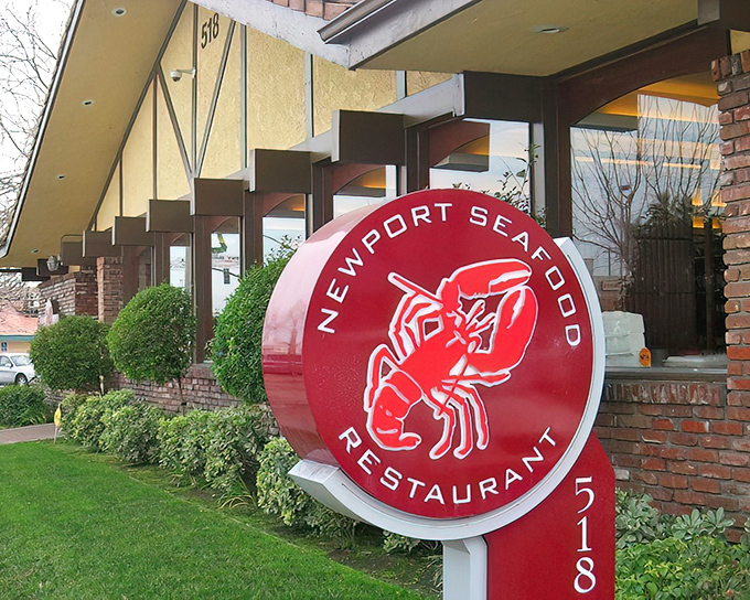 The unassuming brick exterior of Newport Seafood, marked by its simple signage, hides culinary treasures within — like discovering a Rolex in a paper bag.