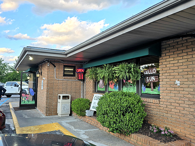 The welcoming entrance to Clyde's, where lush greenery and brick exterior hint at the homey comfort waiting inside. Southern hospitality starts at the doorstep.