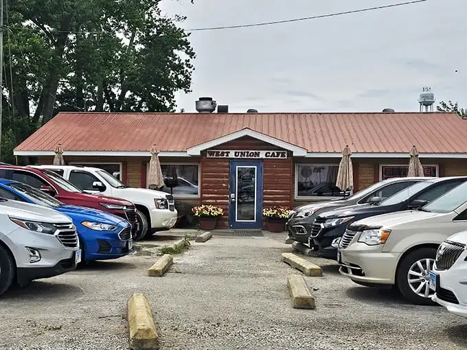 The rustic log cabin exterior of West Union Cafe welcomes hungry travelers with its bright blue door and cheerful yellow mums—rural Illinois' version of a culinary red carpet.