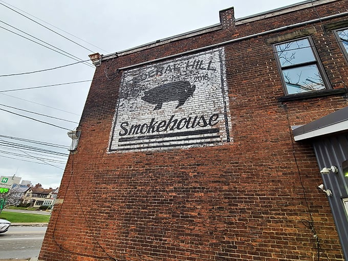 A painted brick mural announces your arrival at barbecue nirvana, where the humble pig silhouette has become a beacon for smoked meat pilgrims.