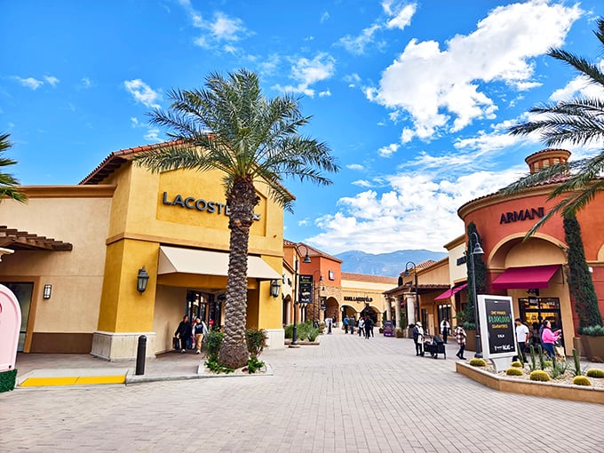 Mediterranean-inspired architecture under perfect blue skies – Lacoste and Armani beckon shoppers into a retail paradise where palm trees provide the only shade your wallet will find.