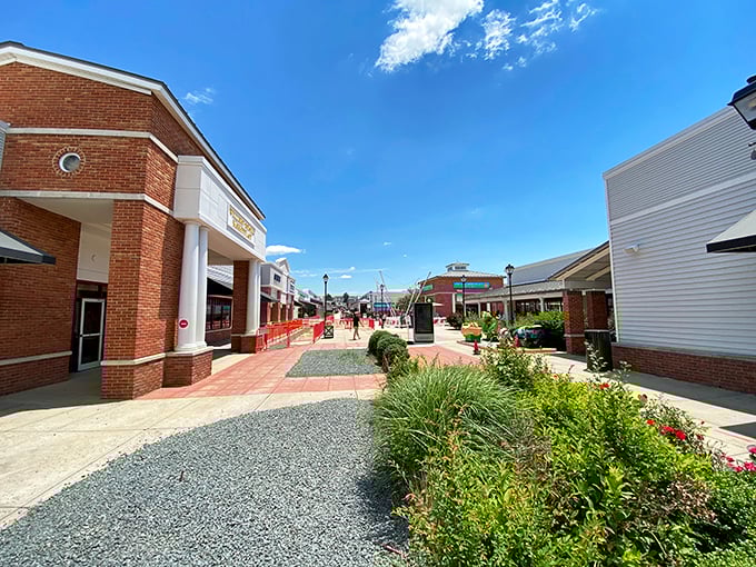 Sunshine bathes the brick facades and welcoming storefronts. This isn't your typical strip mall—it's where Virginia charm meets designer discounts.