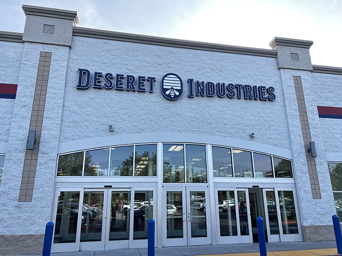 The bright, white façade of Deseret Industries rises with simple pride, its bold lettering and glass doors inviting bargain hunters to step inside and uncover hidden gems at thrift-store prices.