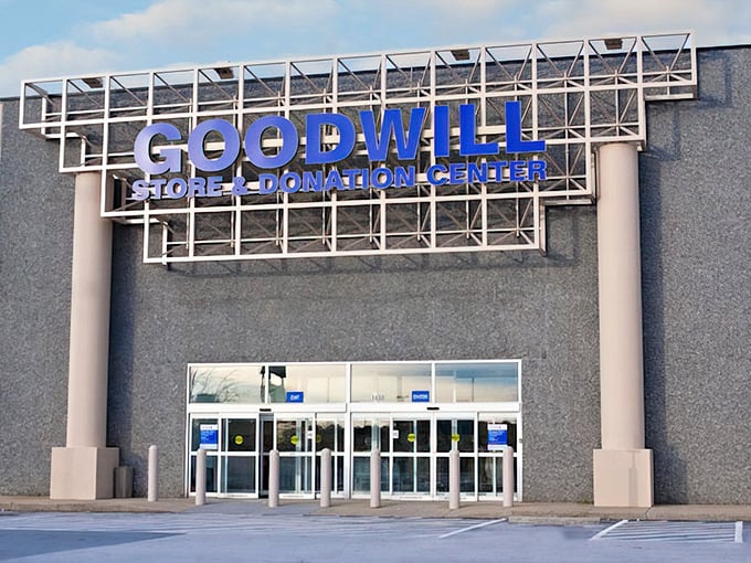 The blue Goodwill sign stands like a beacon of bargain hope against the gray building—retail therapy without the retail prices.
