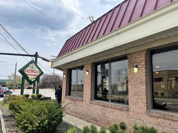 As dusk settles, George's Kitchen's warm glow promises refuge from the day—a burgundy-roofed sanctuary where hungry souls find solace in homestyle cooking.