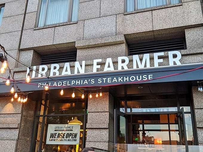 The sleek exterior of Urban Farmer Philadelphia promises modern sophistication while string lights hint at the warm welcome waiting inside.