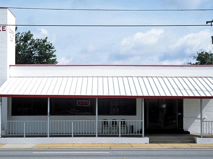 The white brick exterior with its classic red awning isn't trying to be retro – it's the real deal, standing proudly since 1945 in Pensacola's morning landscape.