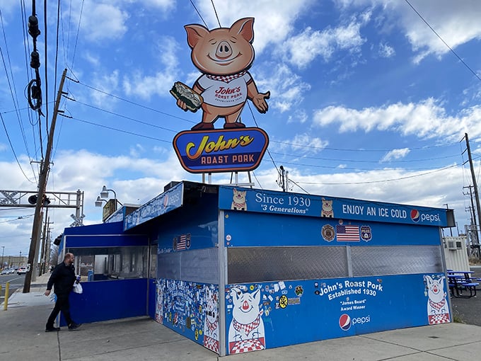 Standing guard like a delicious sentinel, the iconic pig sign welcomes hungry pilgrims to this temple of sandwich artistry nestled in South Philly's industrial landscape.