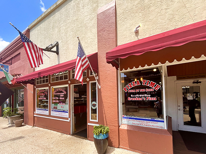 The unassuming storefront of Pizza Time in St. Augustine beckons with its red awnings and American flags—proof that culinary treasures often hide in plain sight.