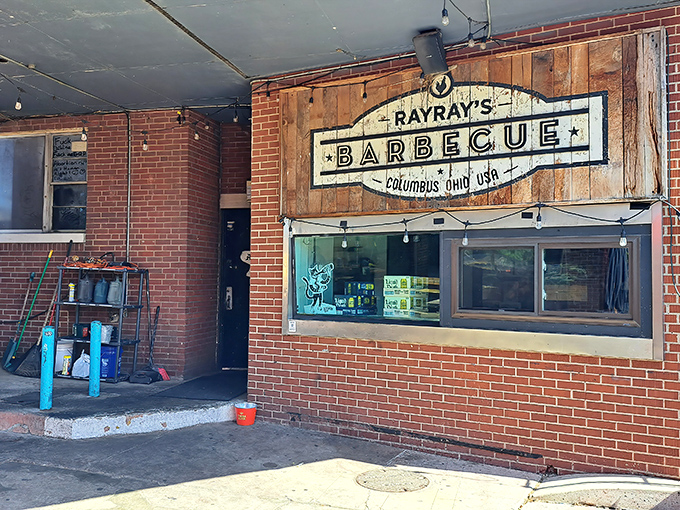 The unassuming brick exterior of Ray Ray's hides barbecue greatness like a superhero's secret identity. That wooden sign promises smoky treasures within.