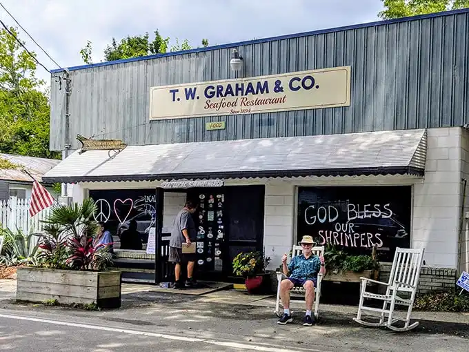 The blue metal exterior with "God Bless Our Shrimpers" chalked on the window tells you everything: this isn't fancy, but it's the real South Carolina deal.