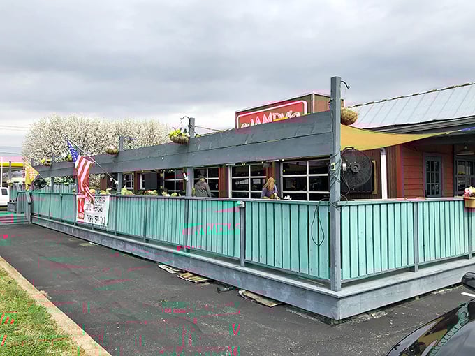 Champy's distinctive turquoise fence and bright red sign create the perfect first impression—like a beacon calling all fried chicken enthusiasts home.