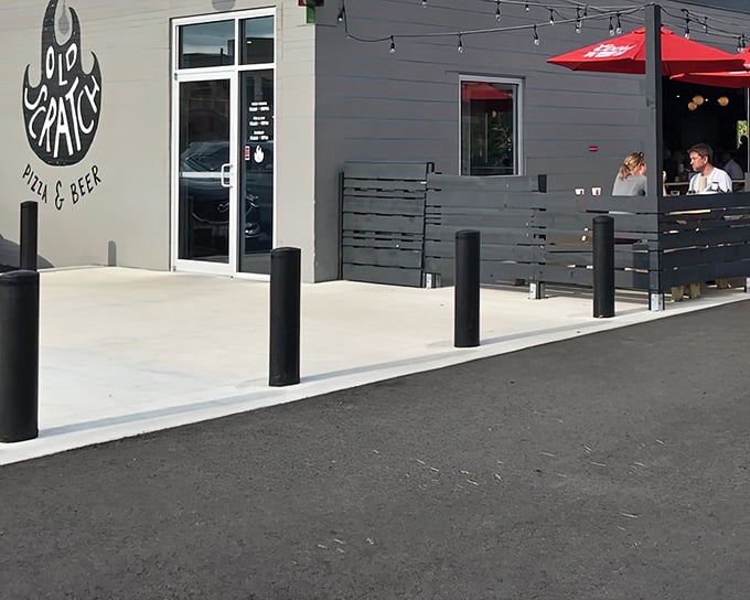 The sleek exterior of Old Scratch Pizza beckons with its minimalist design and inviting patio—proof that great food doesn't need flashy signage to draw a crowd.