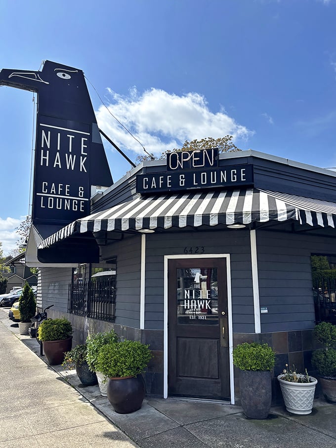 On sunny Portland days, the Nite Hawk's distinctive silhouette stands sentinel against blue skies, promising refuge from both rain and hunger in equal measure.