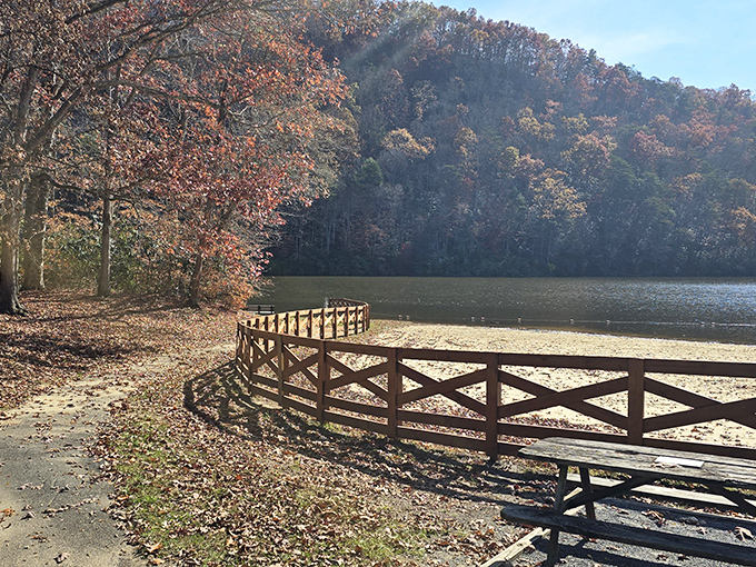 Fall foliage frames this wooden boardwalk like nature's own red carpet leading to mountain lake paradise.