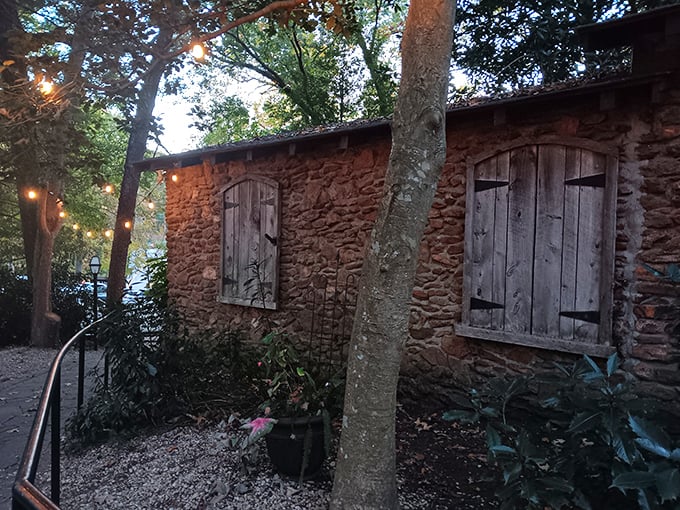 A stone cottage nestled among towering trees isn't your typical restaurant entrance—it's the beginning of a culinary fairy tale in Greenville.