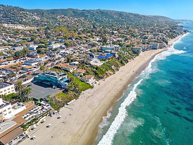 Aerial dreams come true where turquoise waves kiss golden shores. Laguna Beach's coastline unfolds like nature's perfect postcard.