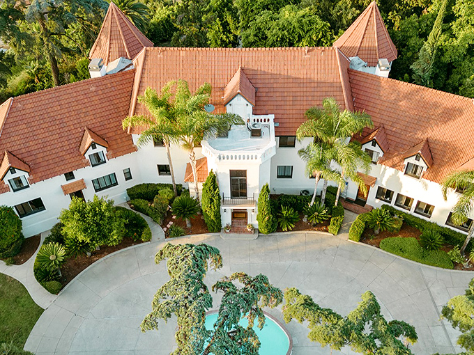 A bird's-eye view of Wrensmoor Castle reveals its fairy tale charm—twin turrets standing like sentinels while palm trees remind you this European fantasy exists in sunny California.