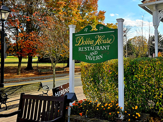 Autumn's golden palette frames the iconic green sign, nature's way of saying "This historic feast awaits, no GPS required."