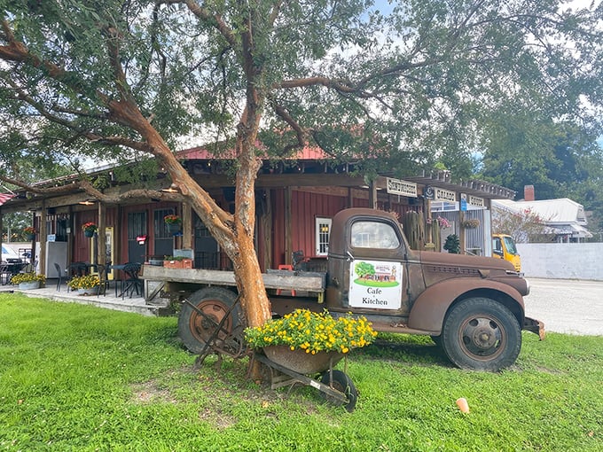 A vintage truck parked outside this rustic red building isn't just decoration—it's a time machine to when general stores were the heart of every neighborhood.