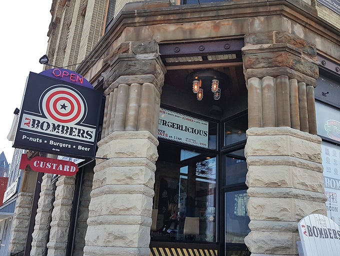 The historic stone facade of AJ Bombers stands like a culinary fortress, its target-logo sign promising a direct hit to your hunger pangs.