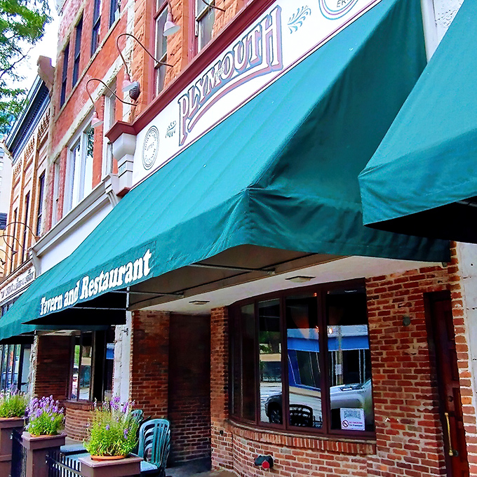 The iconic green awning of Plymouth Tavern stands as Erie's culinary lighthouse, beckoning hungry travelers with the promise of comfort and community.