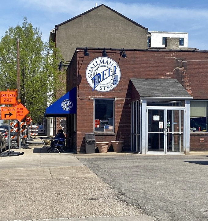 The bright blue awning against red brick is like a culinary bat signal for sandwich lovers across Pittsburgh's Strip District.