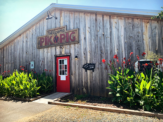 The weathered wooden exterior and bright red door of Pik N Pig isn't trying to impress you—it doesn't need to. The smoke wafting through the air does all the talking.