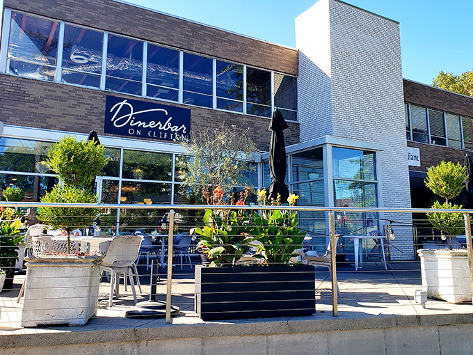 The modern facade of Dinerbar on Clifton welcomes diners with its clean lines and inviting patio space—architectural proof that good taste extends beyond the menu.