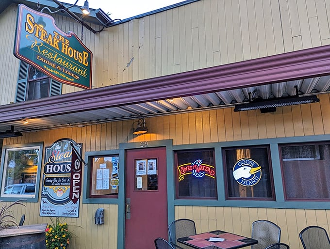 The charming exterior of The Steak House beckons hungry travelers with its classic awning and inviting outdoor seating—a Main Street fixture that promises culinary comfort.