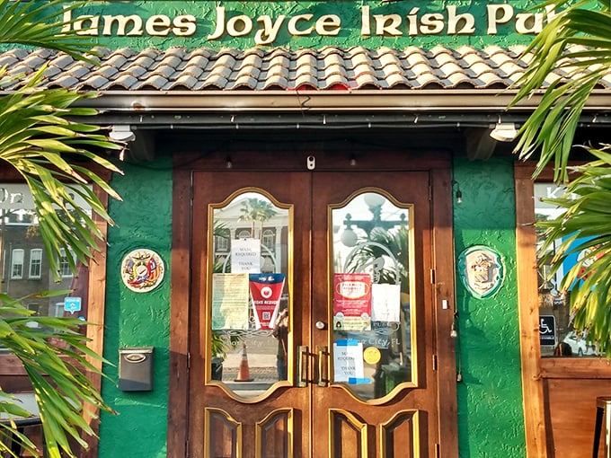 The emerald facade of James Joyce Irish Pub welcomes visitors with wooden doors and palm fronds—Ireland meets Florida in this cultural crossroads.