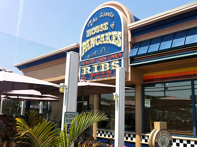 The iconic blue sign of The Little House of Pancakes stands like a beacon for breakfast lovers, promising pancakes, ribs, and culinary happiness.