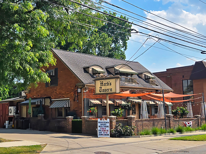 Herb's Tavern welcomes you with classic brick charm and cheerful red umbrellas – like finding a neighborhood gem you've been missing your whole life.