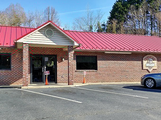 The iconic red roof of Checkered Pig BBQ & Ribs stands out like a beacon for hungry travelers. Barbecue paradise awaits behind those brick walls.