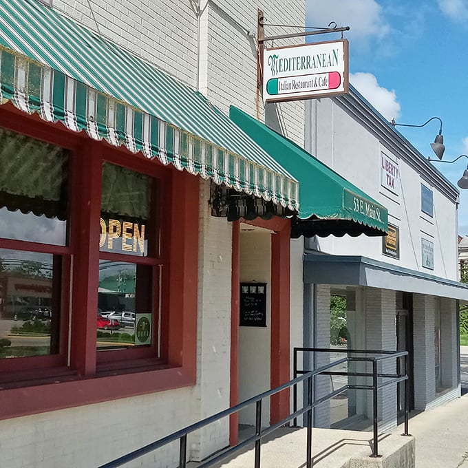 The iconic green and white striped awning of The Mediterranean is like a beacon for hungry travelers on Wilmington's Main Street, promising authentic flavors behind its modest façade.