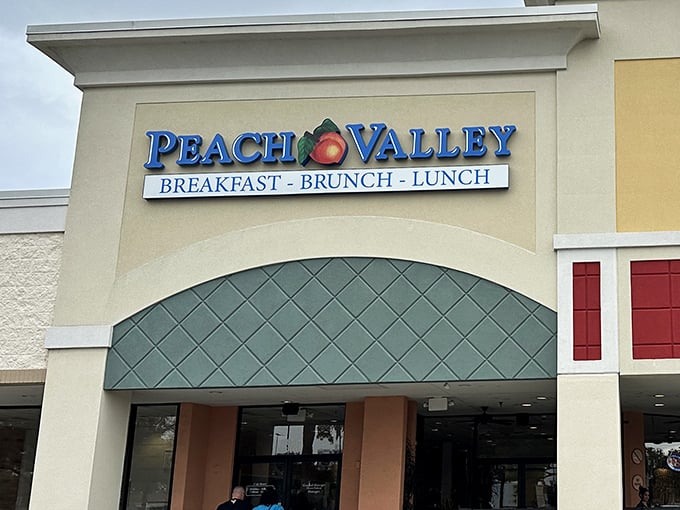 The welcoming facade of Peach Valley Cafe beckons breakfast enthusiasts with its cheerful signage and promise of morning delights that outshine Orlando's flashier attractions.