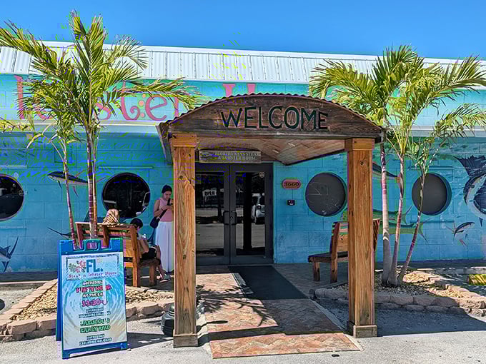 The turquoise facade with nautical portholes and wooden "WELCOME" arch isn't just inviting—it's practically shouting "vacation mode activated!" in true Keys style.