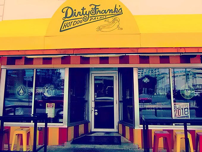 The vibrant yellow and red striped awning of Dirty Frank's beckons like a carnival of culinary delights waiting to happen.