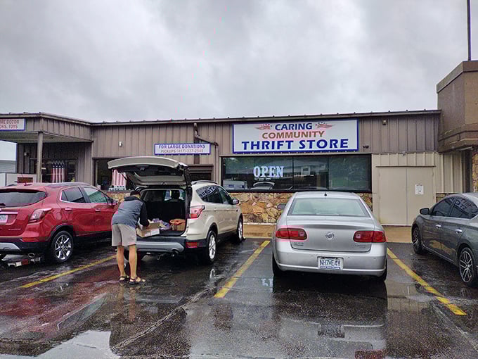 The gateway to treasure hunting! Caring Community Thrift Store's bold red and blue sign promises adventures in secondhand shopping that await inside.