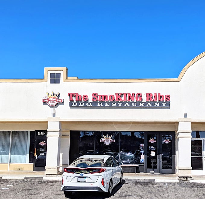 The bold red sign against the clear blue California sky isn't just advertising – it's a beacon for barbecue pilgrims seeking smoky salvation in Garden Grove.