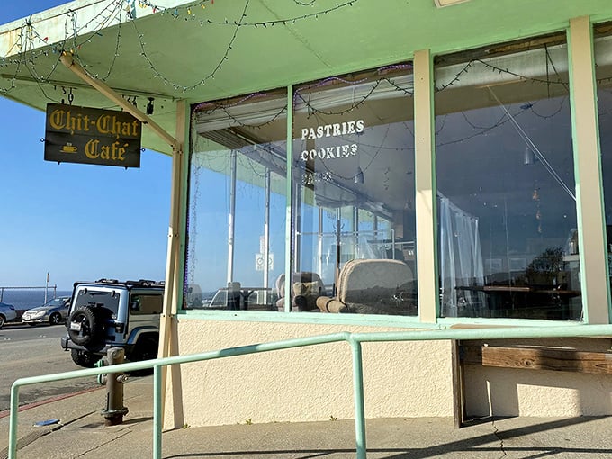 Morning light streams through windows framing the Pacific, while the cafe's weathered sign promises pastries and conversation in equal measure.