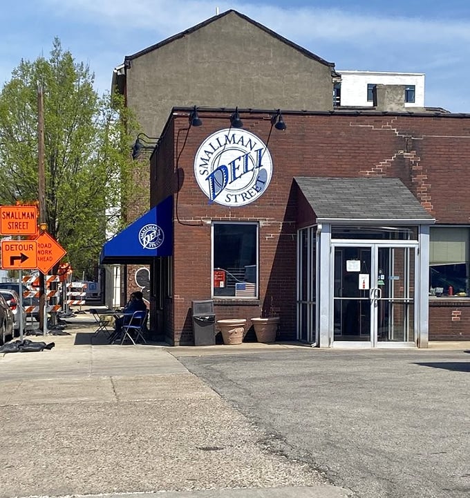The bright blue awning against red brick is like a culinary bat signal for sandwich lovers across Pittsburgh's Strip District.