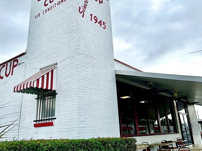 The white brick exterior with its classic red awning isn't trying to be retro – it's the real deal, standing proudly since 1945 in Pensacola's morning landscape.