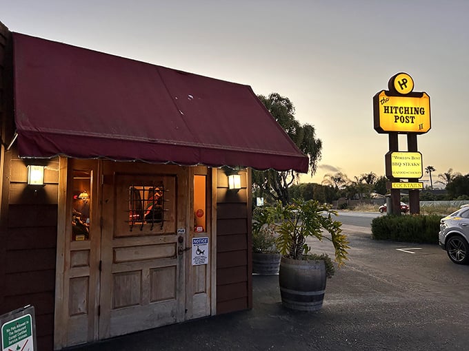 The unassuming exterior of Hitching Post 2 proves once again that culinary greatness often hides behind modest facades. That burgundy awning has sheltered countless food pilgrims.
