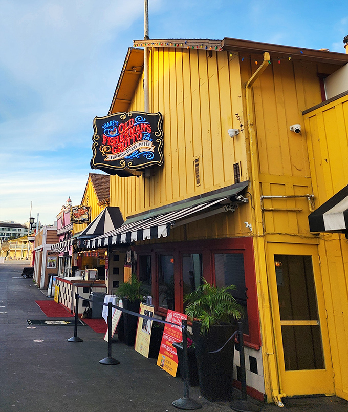 The iconic blue-and-gold sign of Old Fisherman's Grotto stands like a maritime beacon, promising seafood treasures within those Spanish-style walls.