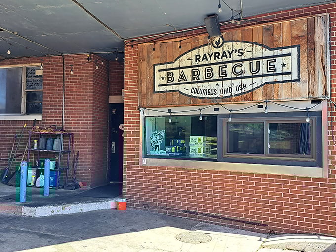 The unassuming brick exterior of Ray Ray's hides barbecue greatness like a superhero's secret identity. That wooden sign promises smoky treasures within.